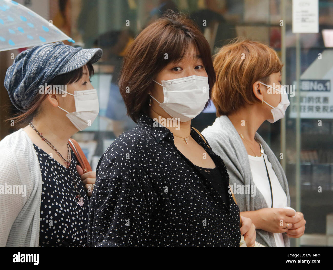 Seoul, South Korea. 26th June, 2015. Wearing a mask, people walk at a ...
