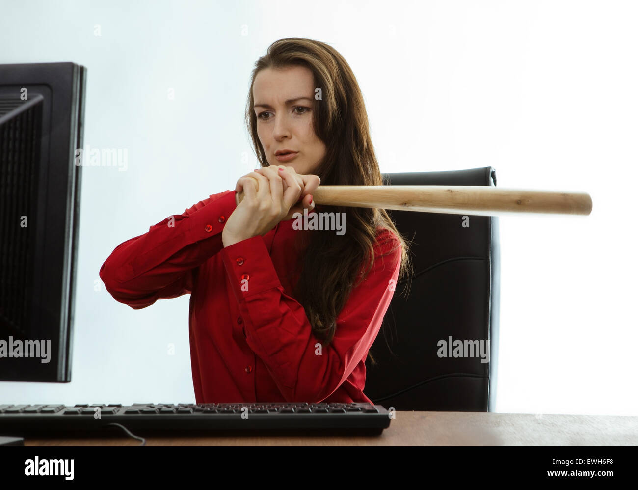 woman sitting at her desk holding a baseball bat getting mad at her ...