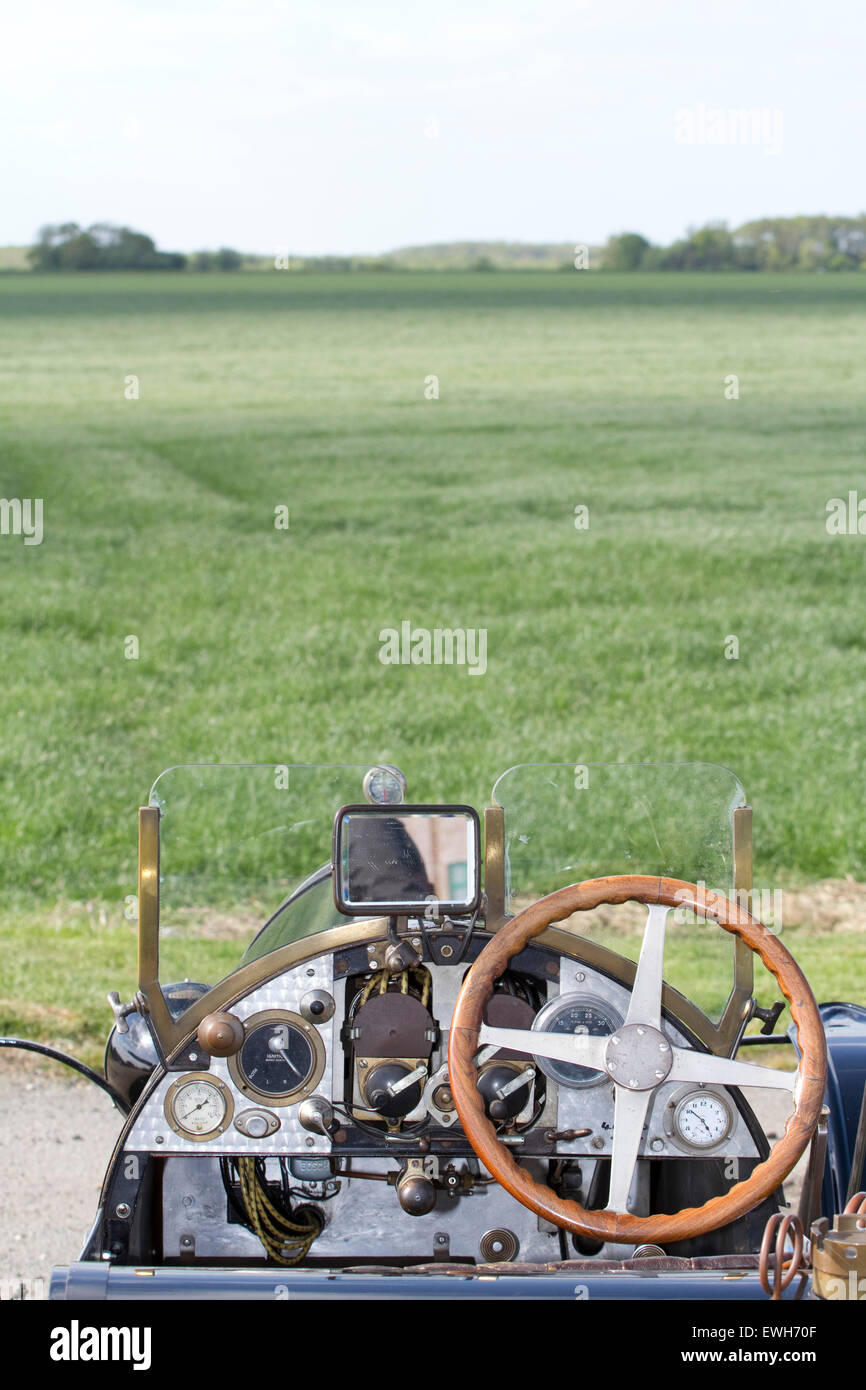 Rear view of a vintage open topped Bugatti motorcar in a grass field ...