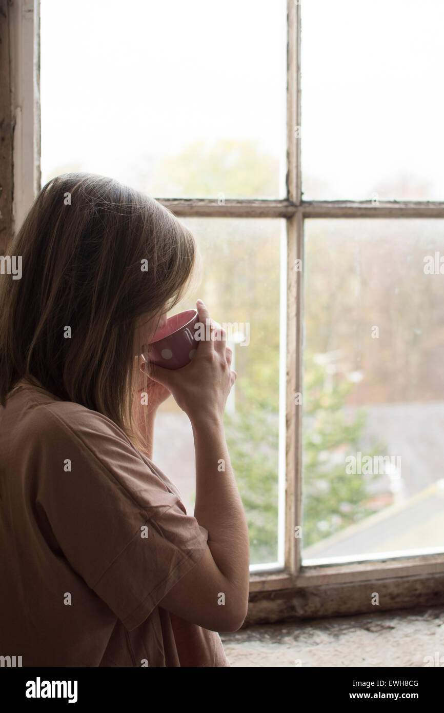 Woman drinking tea by the window Stock Photo - Alamy