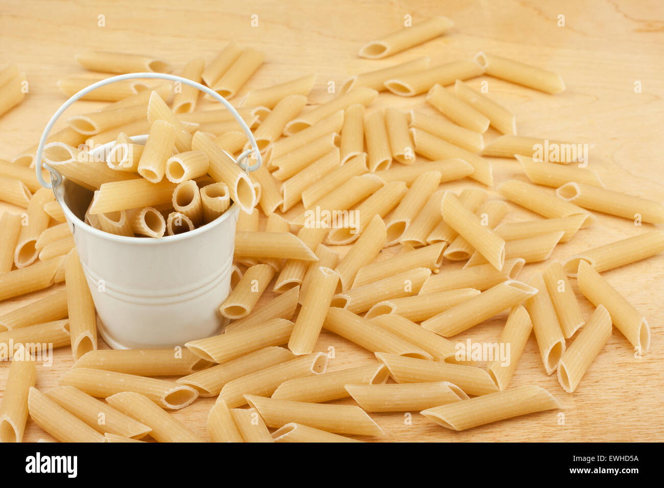 White bucket with pasta on the wooden floor, as a background Stock ...