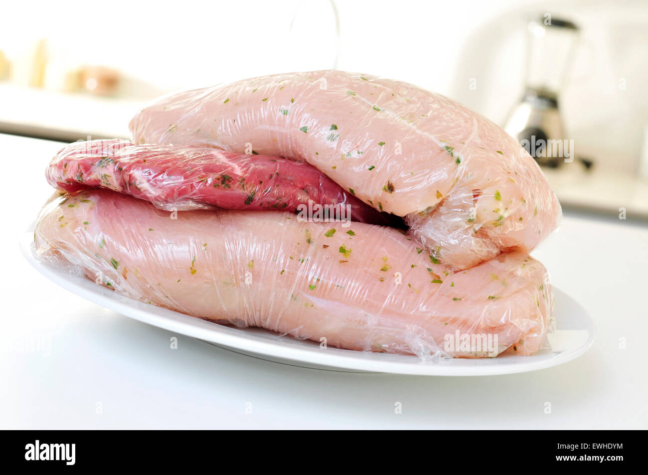 a plate with some pieces of different raw meat wrapped in plastic on ...