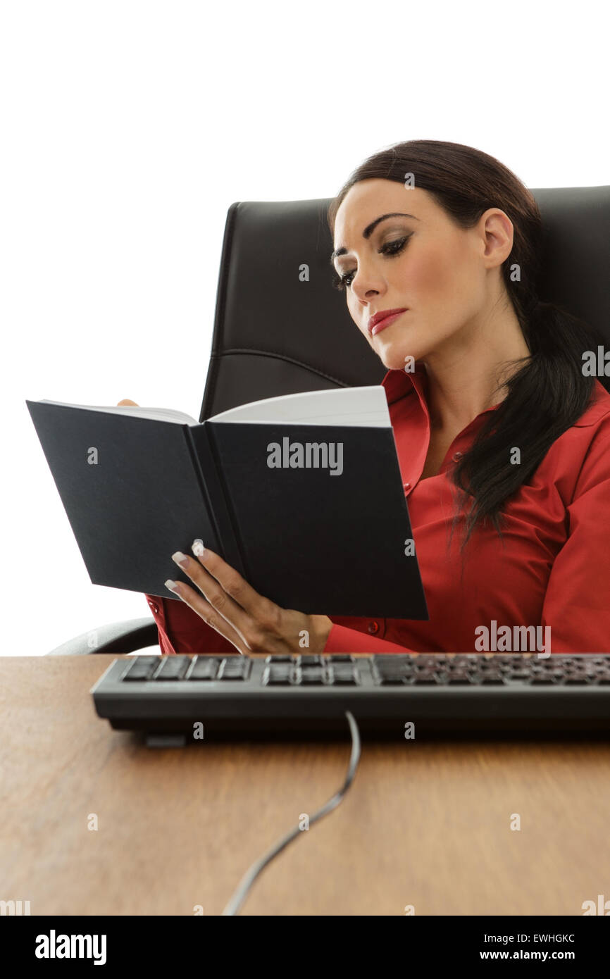 business woman siting at her office desk reading a book Stock Photo - Alamy