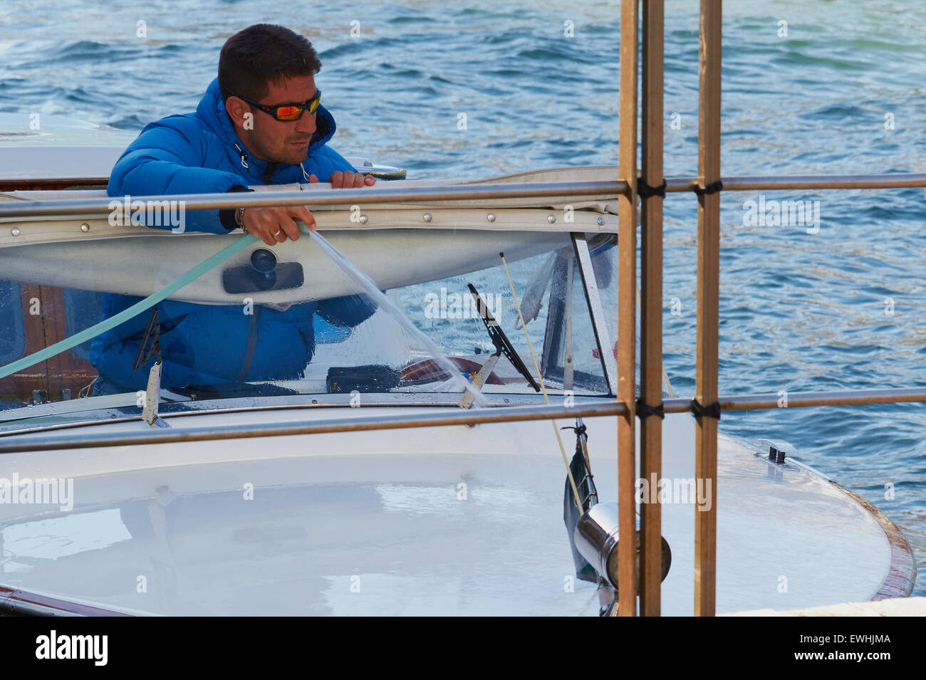 Water taxi driver washing his boat with hosepipe Venice Veneto Italy ...