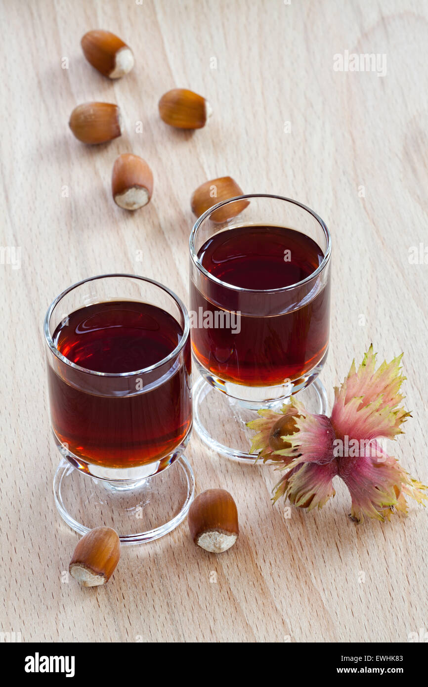 Homemade Hazelnut liqueur in two glasses and hazelnuts on wooden ...