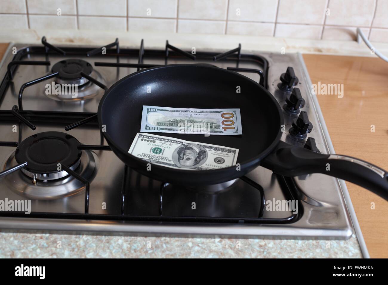 hundred dollar bills in a frying pan Stock Photo - Alamy
