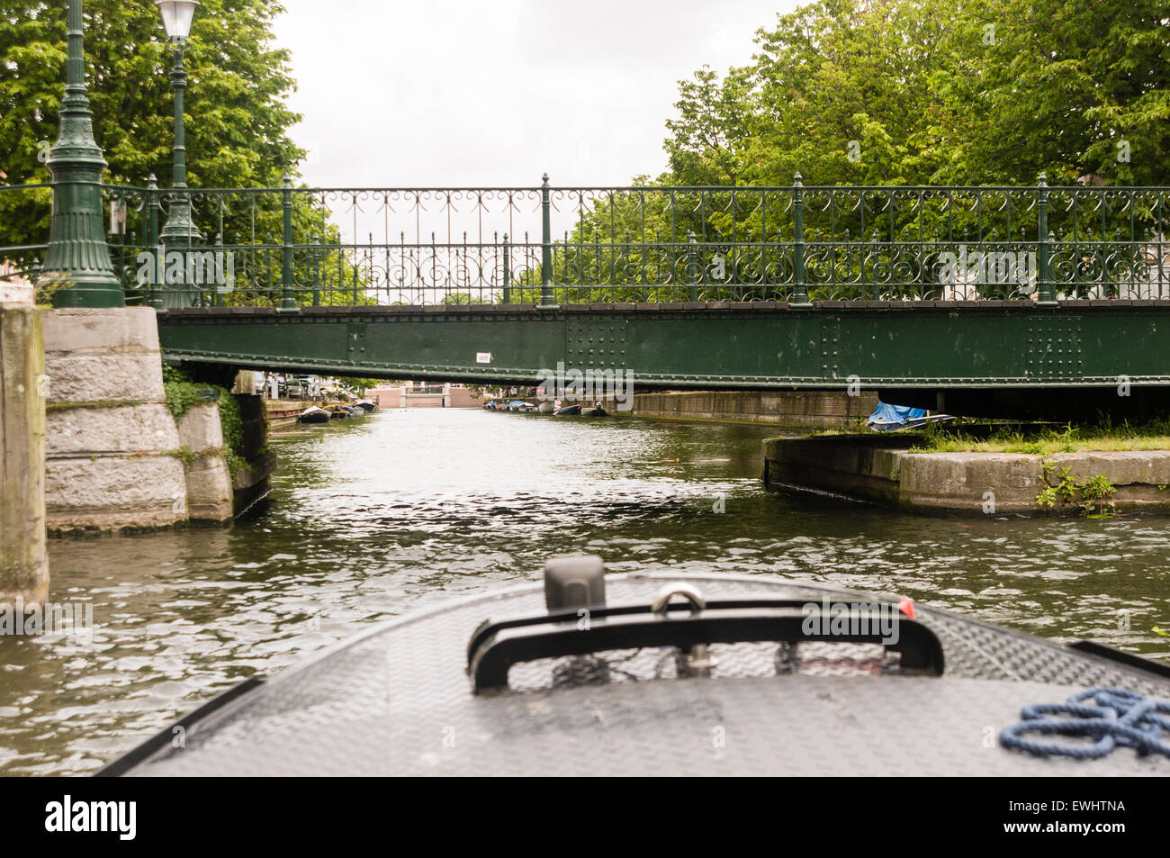 Canal boat sails underneath a low bridge in The Hague, Netherlands ...