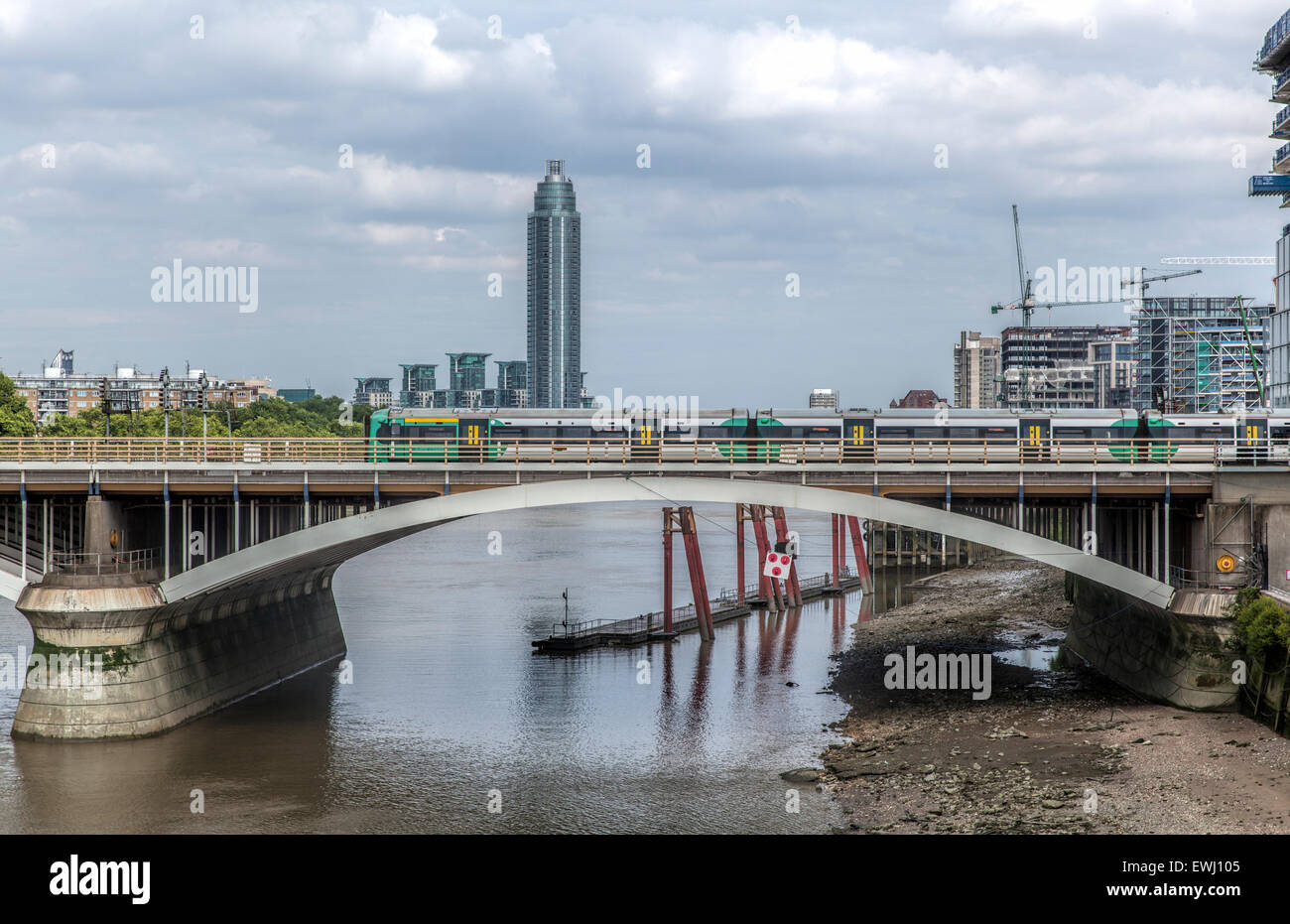 Train crosses the railway bridge over the River Thames at Battersea in ...