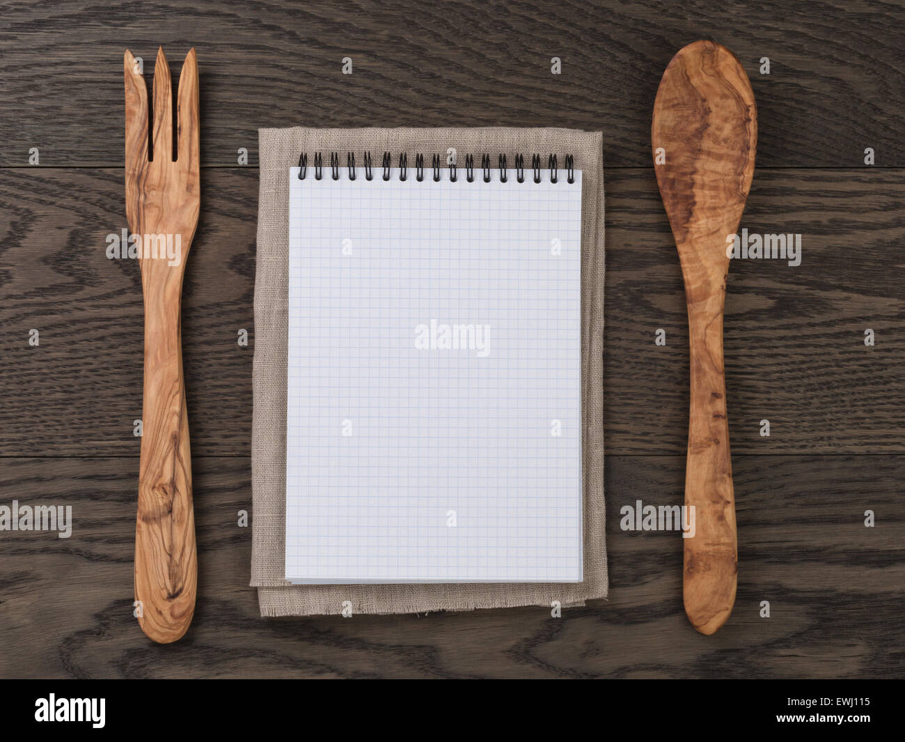 notebook with spring on wood table with wooden utensils for recipe ...
