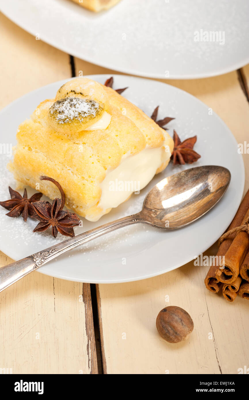 fresh homemade cream roll cake dessert and spices over white rustic ...