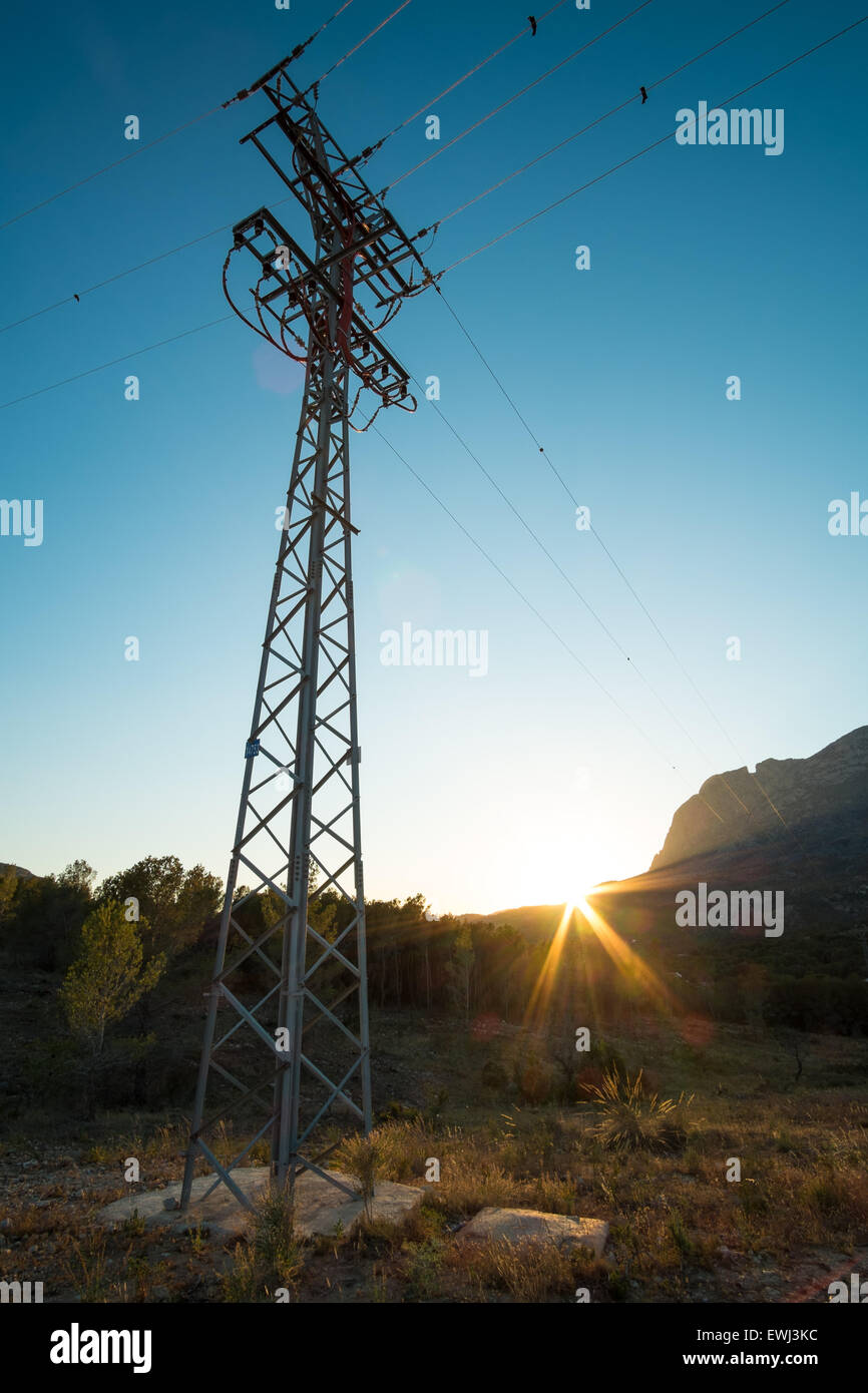 Large electricity pylon in a hilly landscape at sunrise Stock Photo - Alamy
