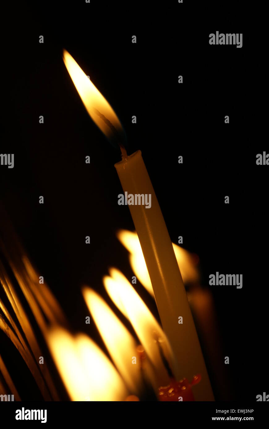 Shamash candle on a menorah Stock Photo - Alamy