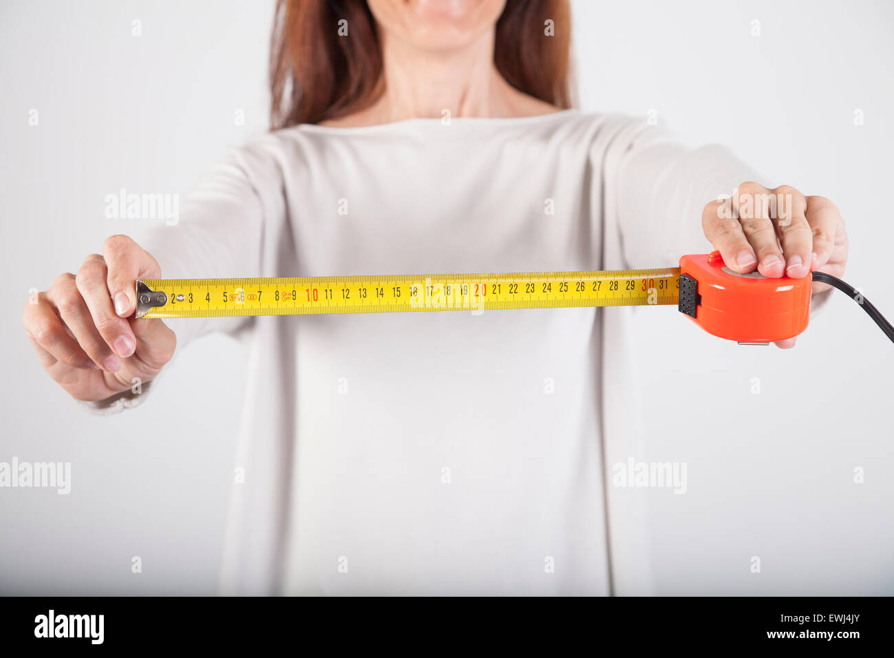 yellow open measure tape in woman hand fingers isolated over white ...