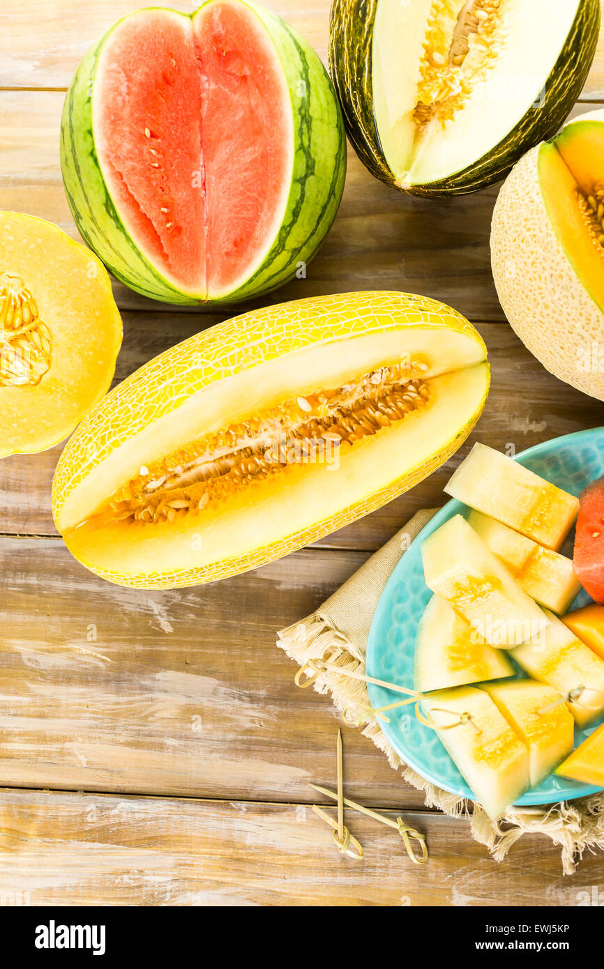 Variety of organic melons sliced on wood table Stock Photo - Alamy