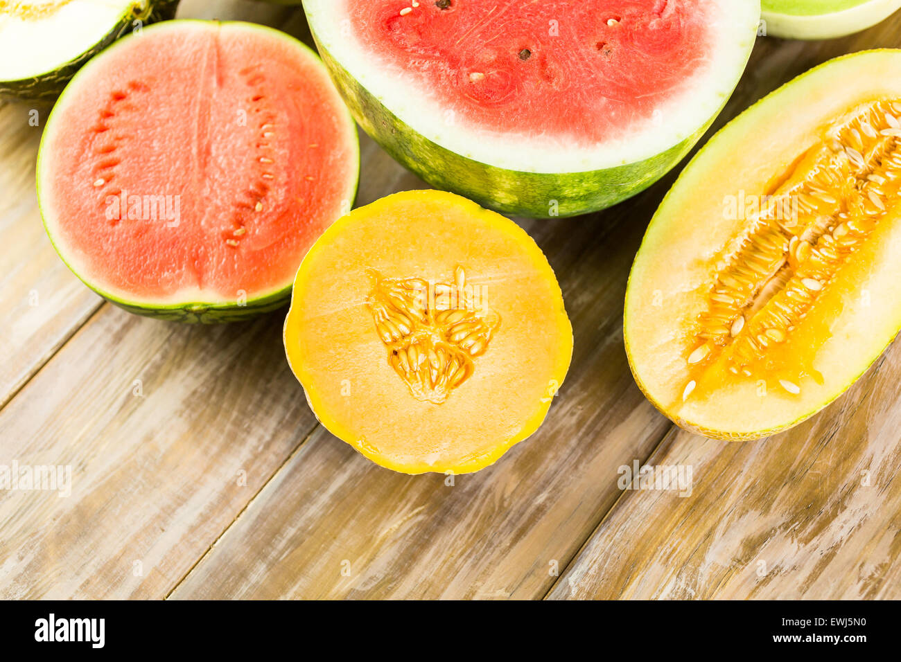 Variety of organic melons sliced on wood table Stock Photo - Alamy