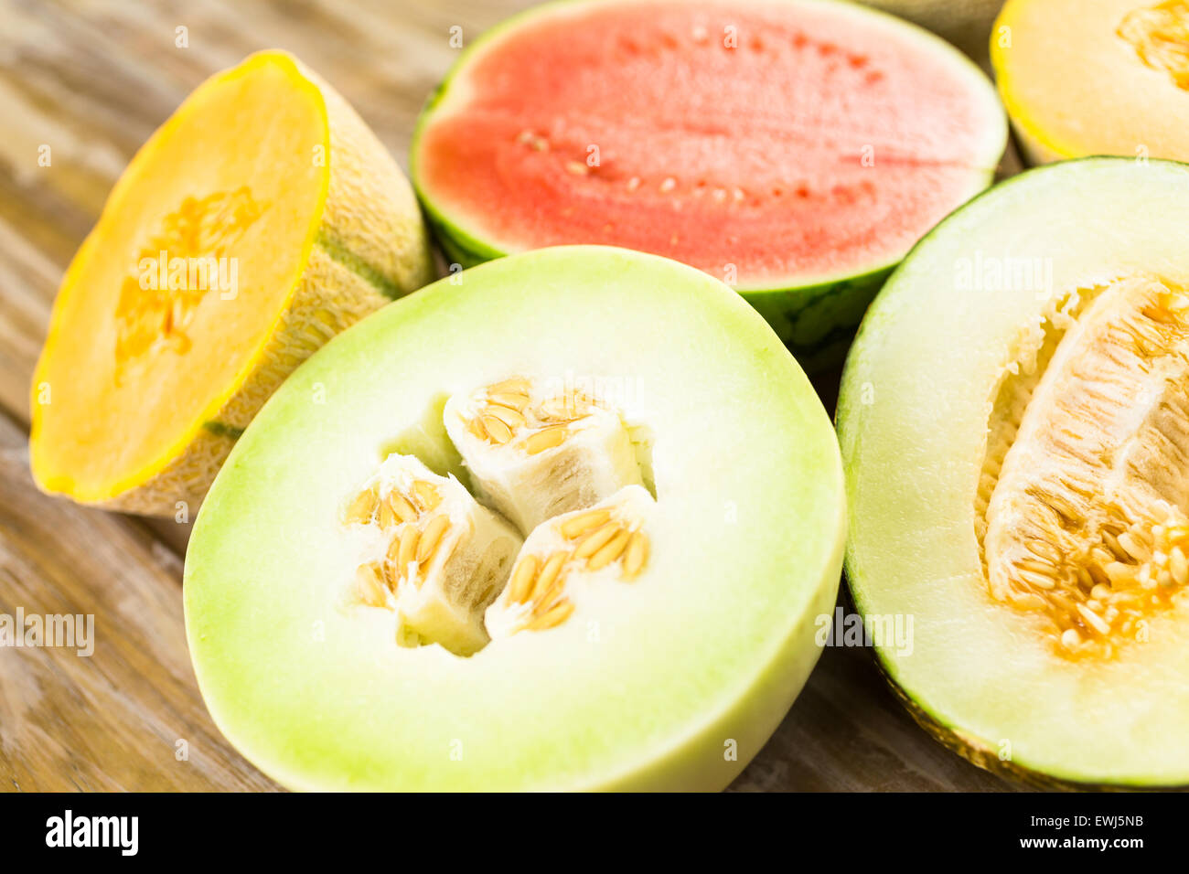 Variety of organic melons sliced on wood table Stock Photo - Alamy