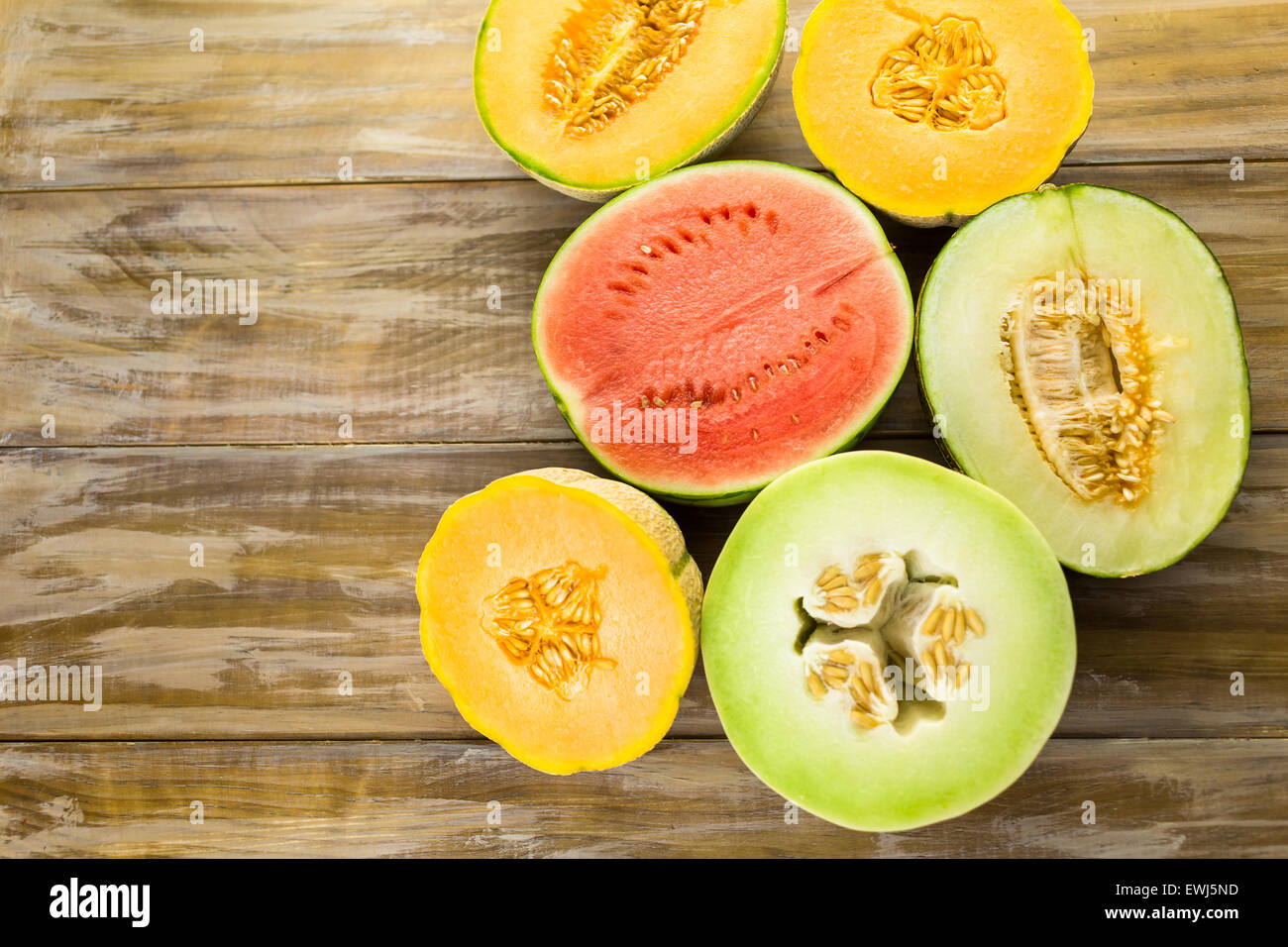 Variety of organic melons sliced on wood table Stock Photo - Alamy