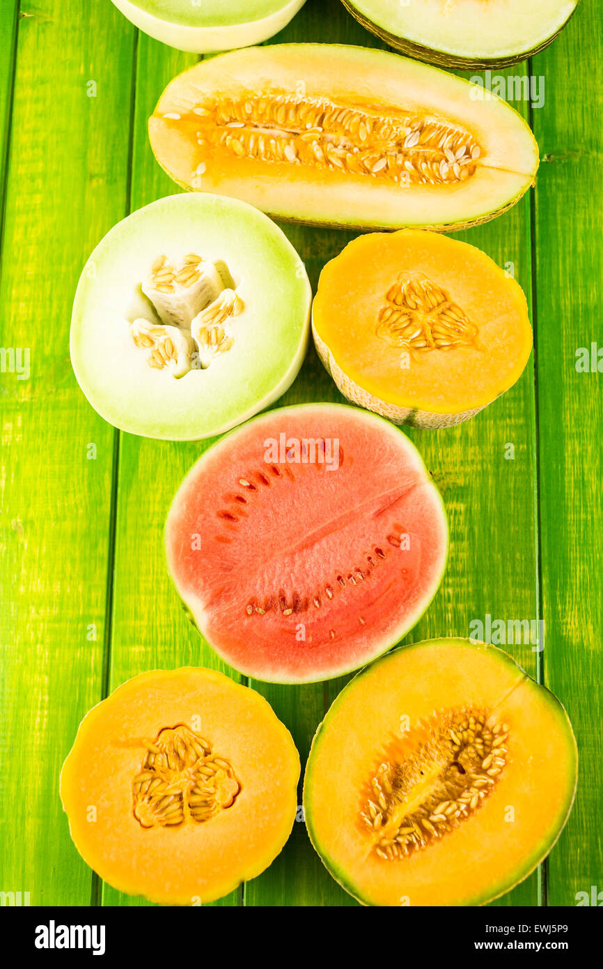 Variety of organic melons sliced on wood table Stock Photo - Alamy