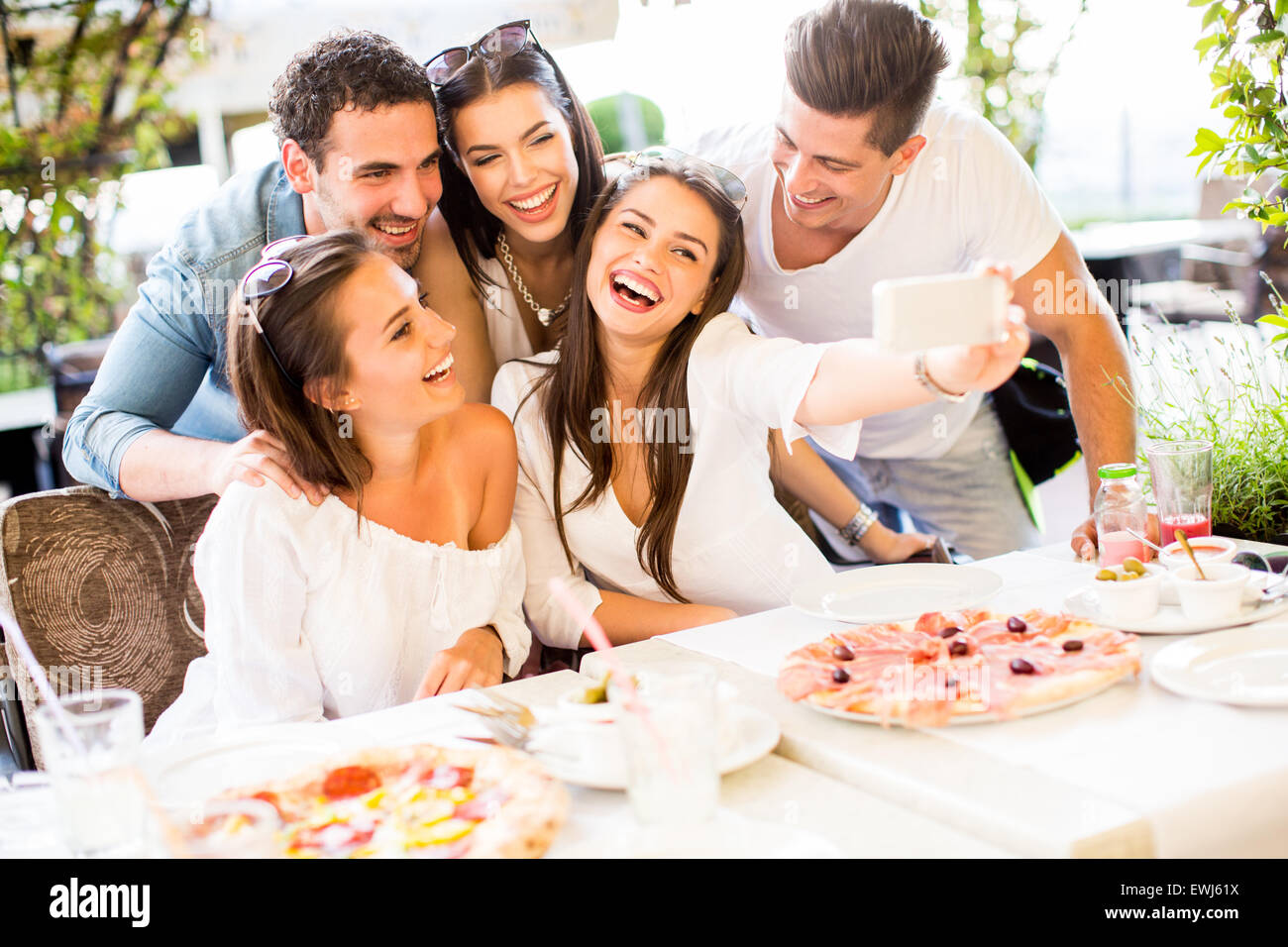 Young people taking photo by the table Stock Photo - Alamy