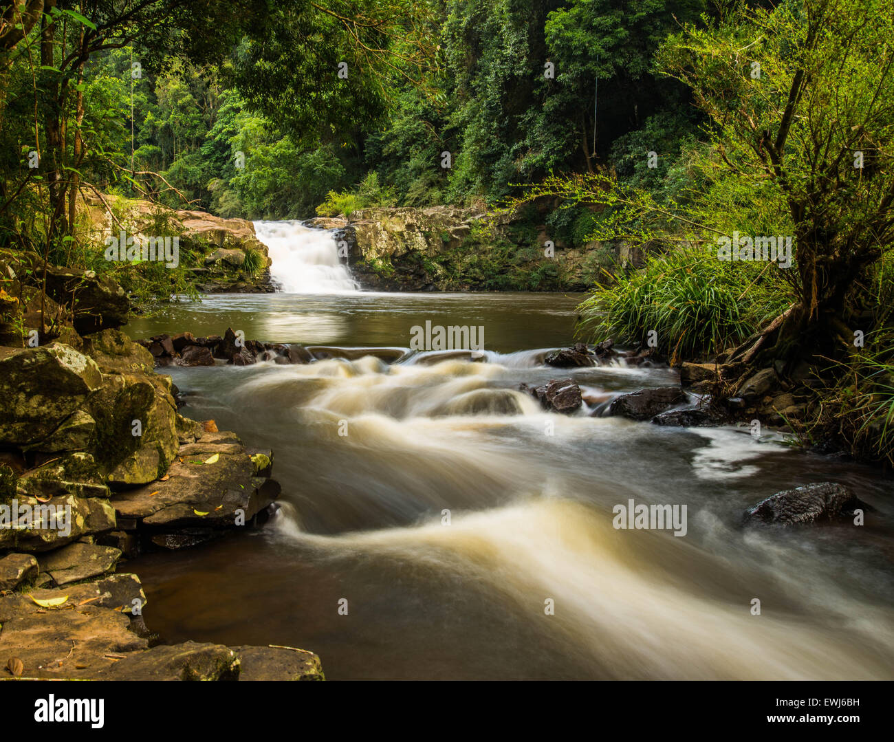 waterfall flowing past swimming hole Stock Photo - Alamy
