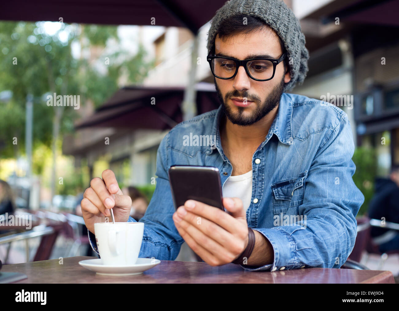 Outdoor portrait of modern young man with mobile phone in the street ...