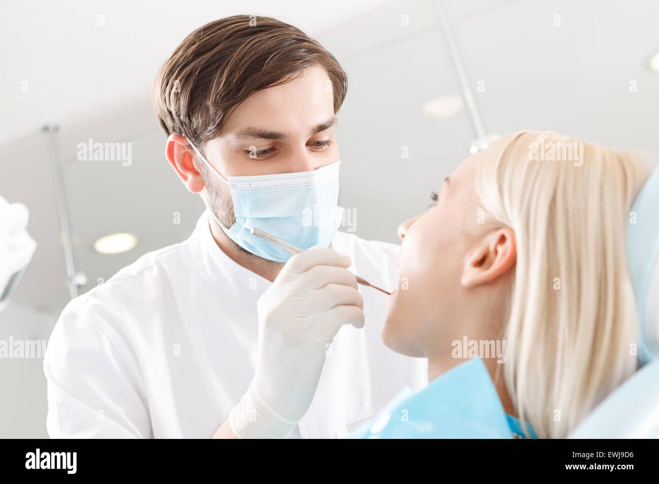 Dentist examining teeth of his client Stock Photo - Alamy