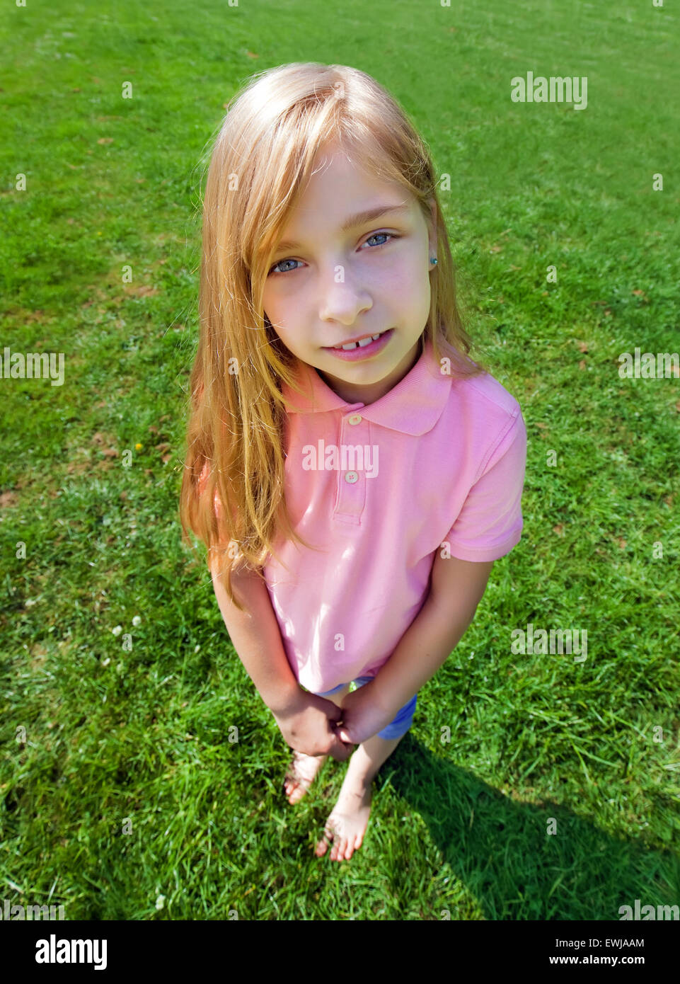 beautiful child standing on green grass and looking up Stock Photo - Alamy