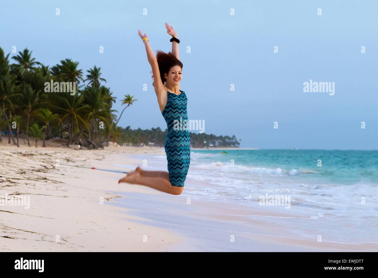 Young beautiful woman jumping on a tropical beach Stock Photo - Alamy