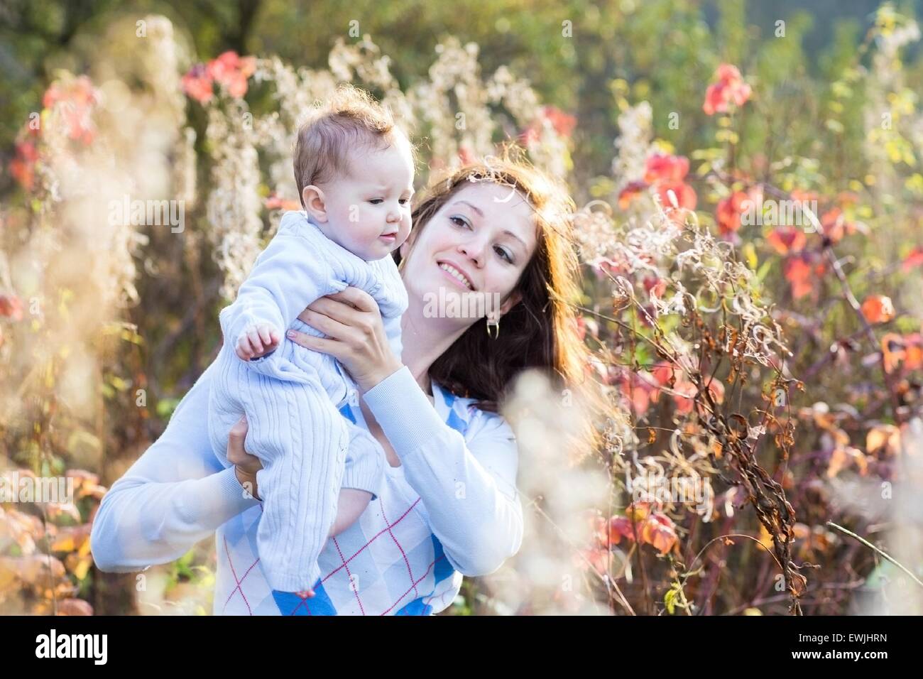 Young happy mother hugging her little baby in a sunny autumn park Stock Photo - Alamy
