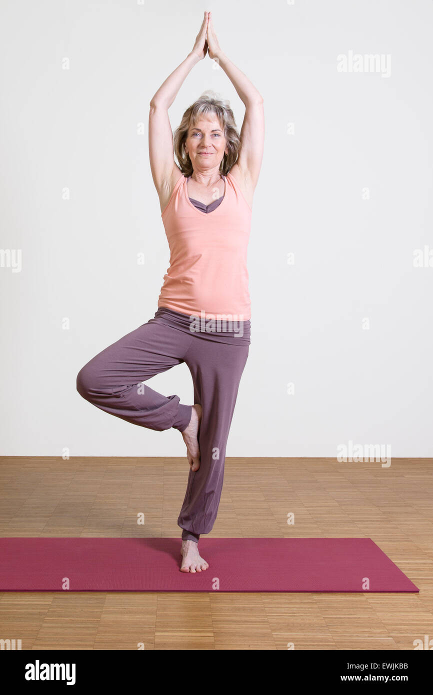 female yoga coach shows exercise Stock Photo - Alamy