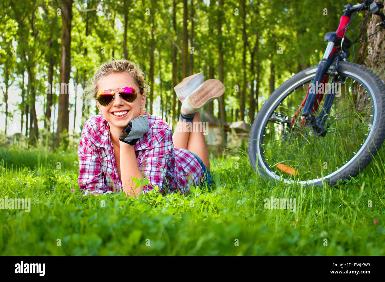 Young cyclist relaxation lying in the fresh green grass Stock Photo - Alamy