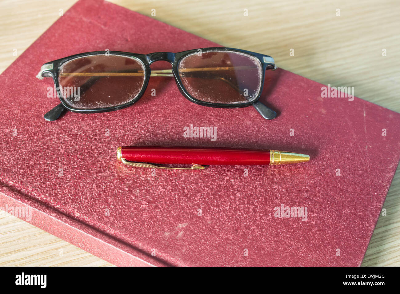 Pen and glasses on a dusty old books Stock Photo - Alamy