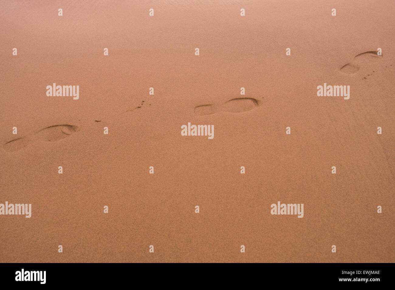 Three Footprints on the Beach Stock Photo - Alamy