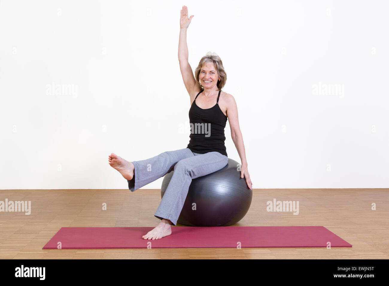 female coach shows exercise using a pilates ball Stock Photo - Alamy