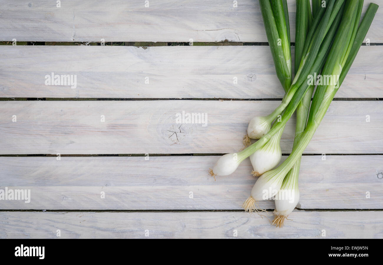 Scallions on a bright wooden table Stock Photo - Alamy