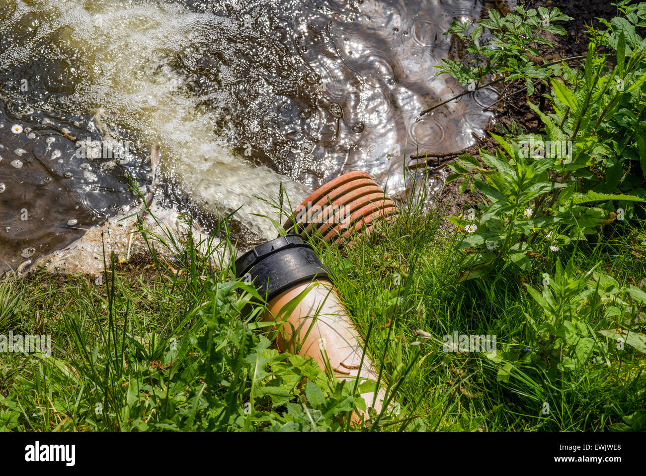 Pipe with spill water at a lake Stock Photo - Alamy