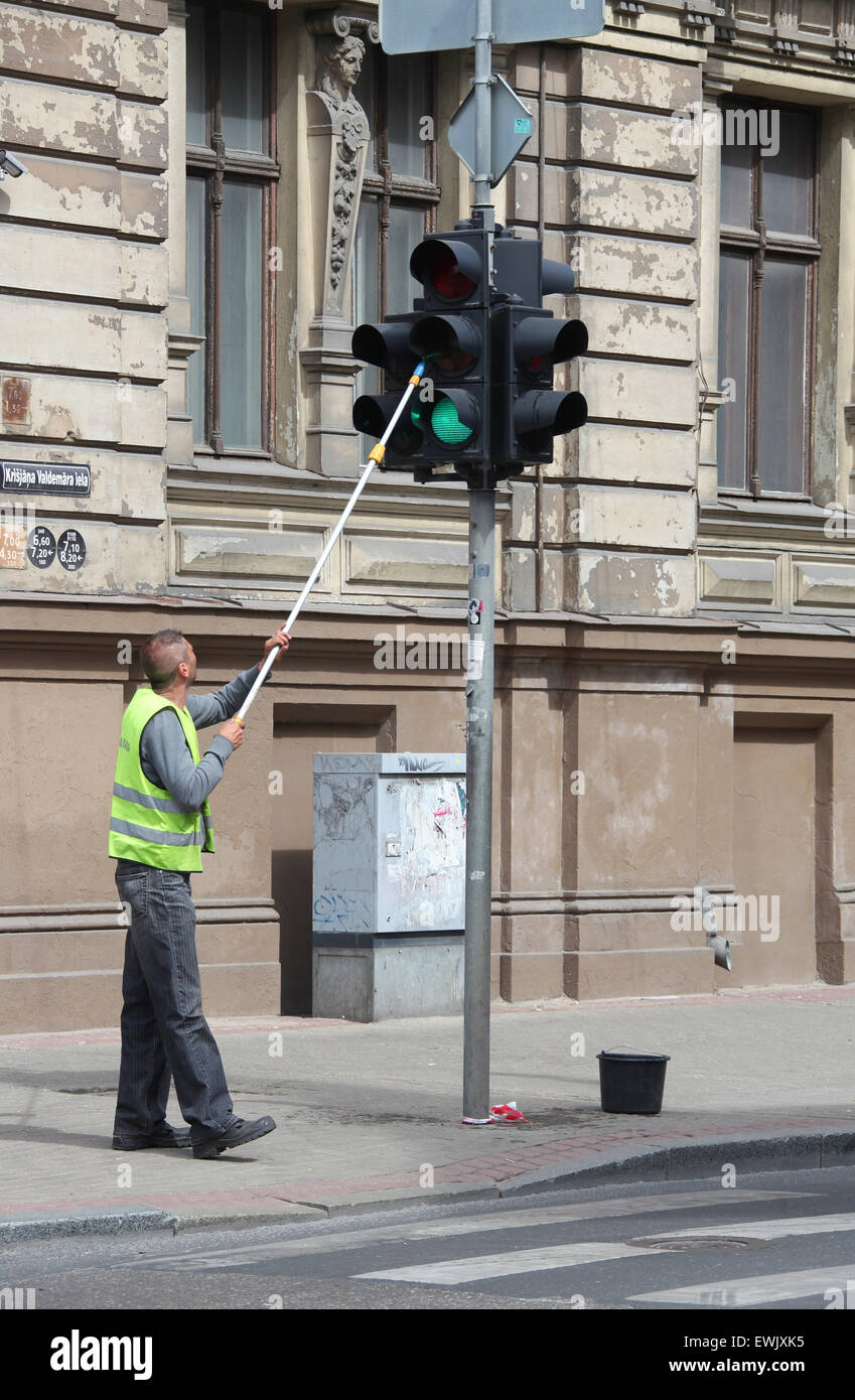Man cleaning traffic lights in Riga Stock Photo - Alamy
