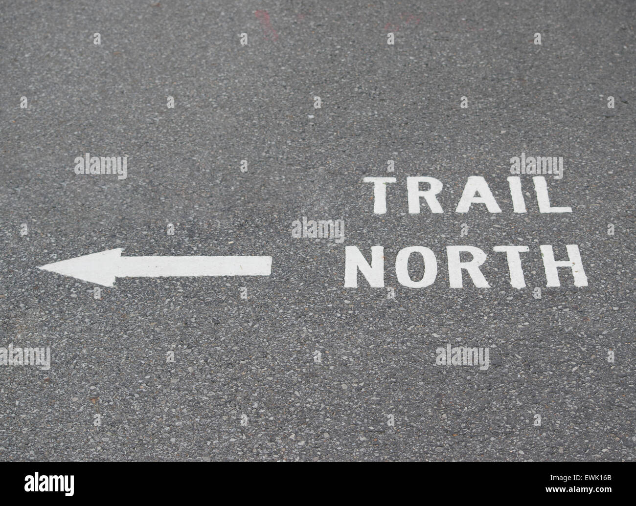 trail sign and arrow painted on gray pavement Stock Photo - Alamy