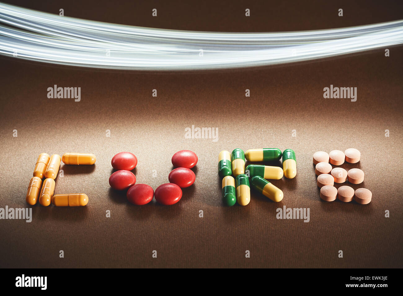 Word cure written with various different pills and tablets, lighting ...