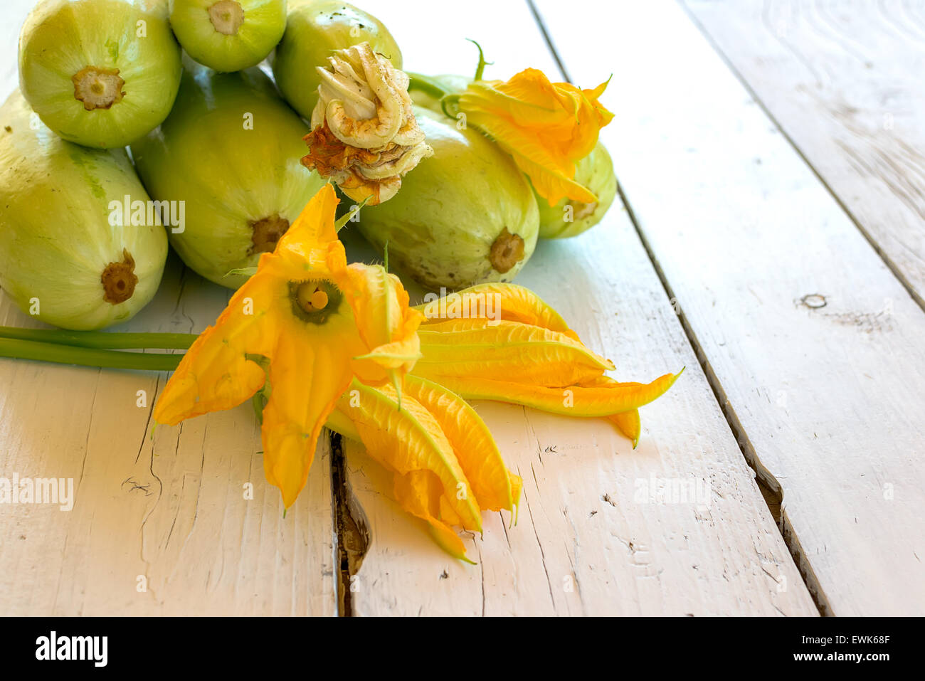 Bunch courgettes and courgettes flowers on a white table Stock Photo ...
