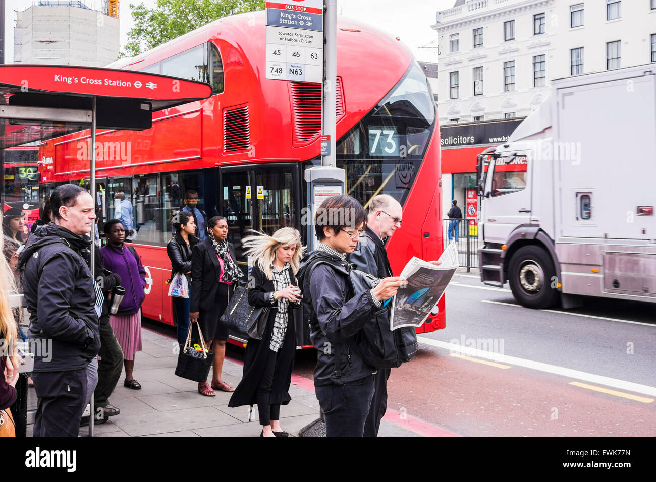Commuters at bus stop outside of King's Cross railway station London ...
