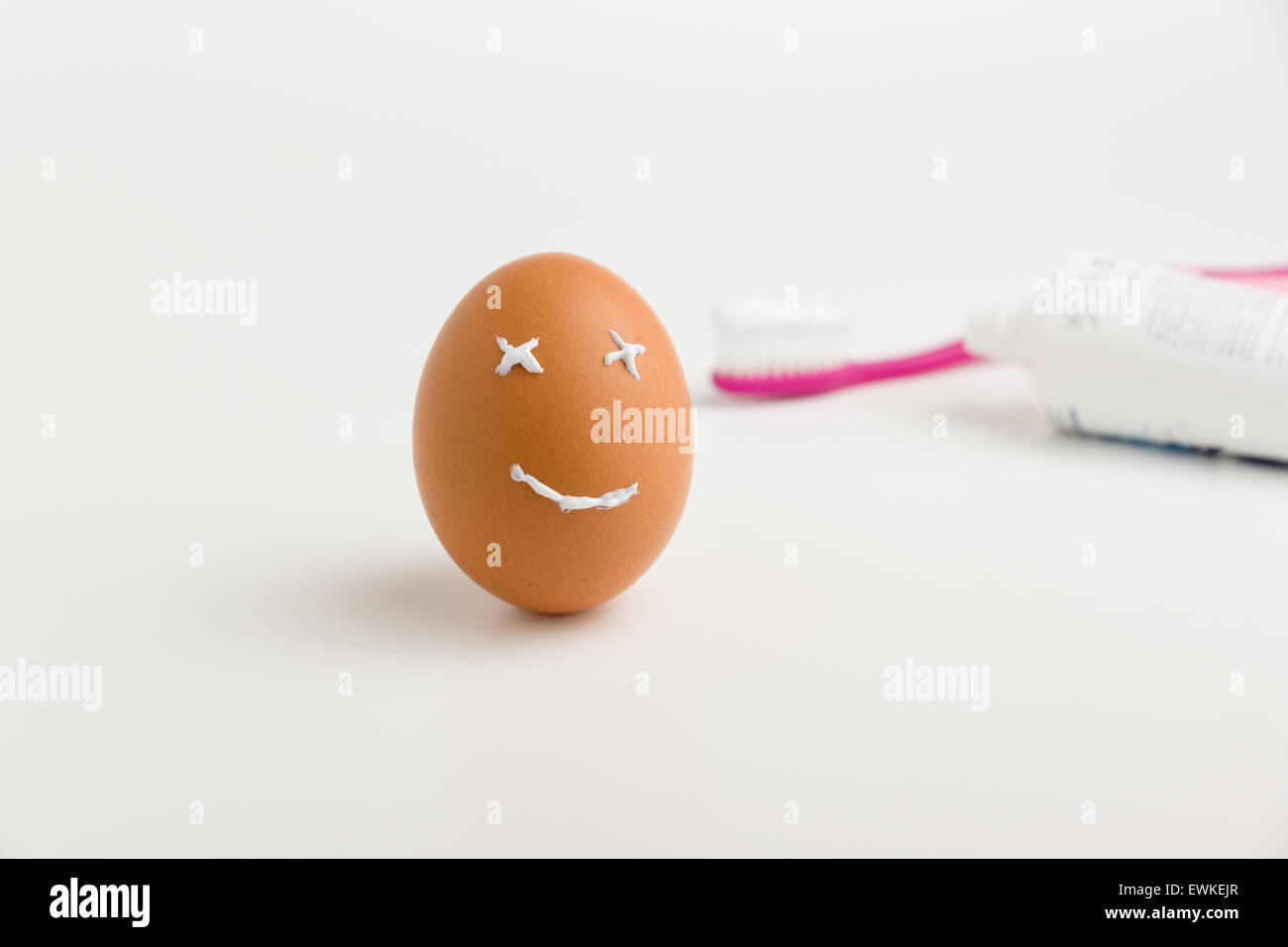 egg with the drawn smile in the foreground and a toothpaste with a ...