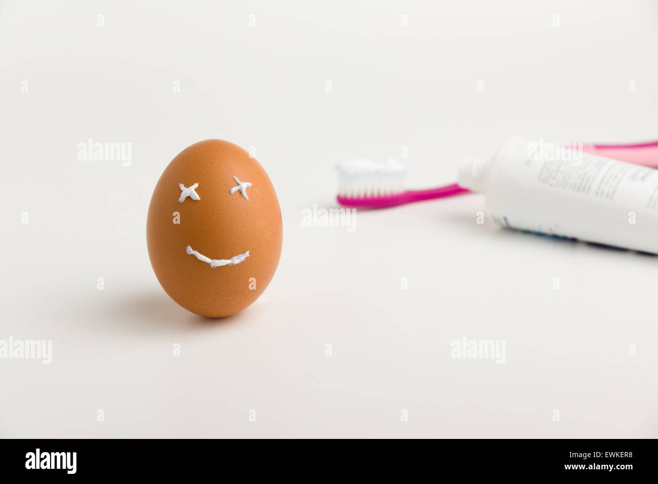 egg with the drawn smile in the foreground and a toothpaste with a ...