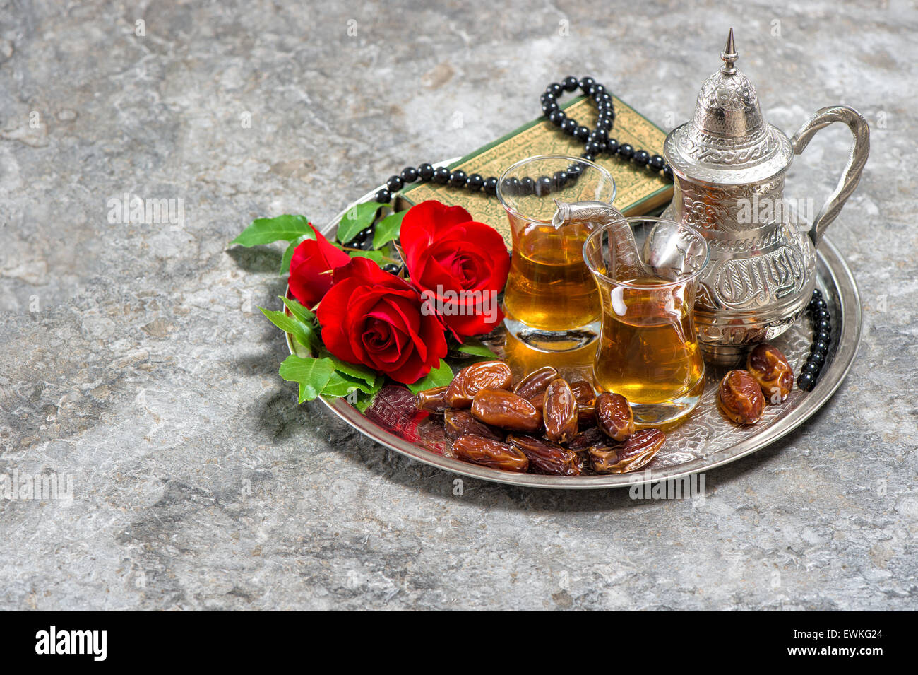 Tea, dates fruits, red rose flower, holy book quran and rosary. Islamic ...