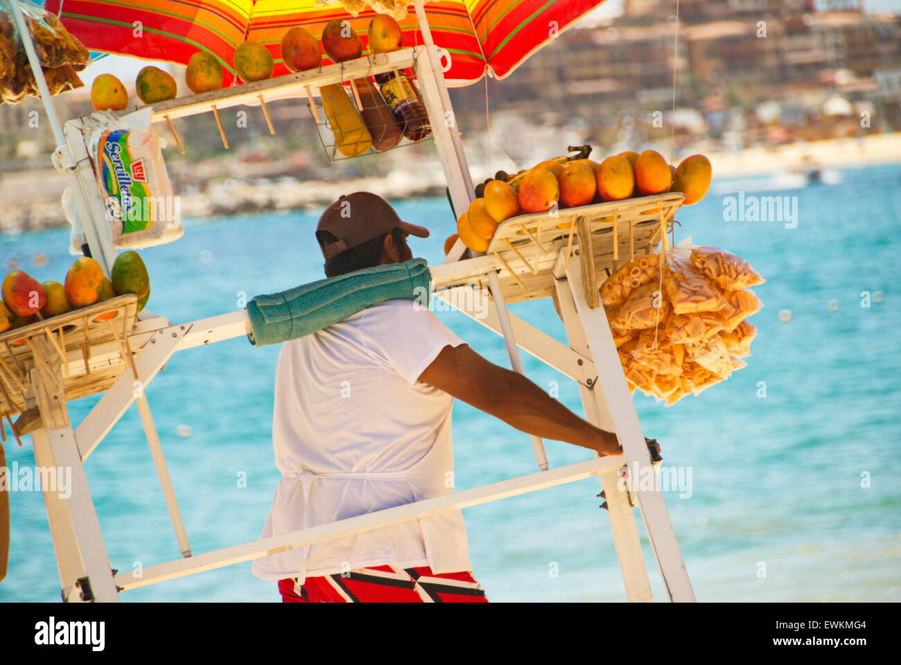Working local man selling mangos on the beach in Mexico Stock Photo - Alamy