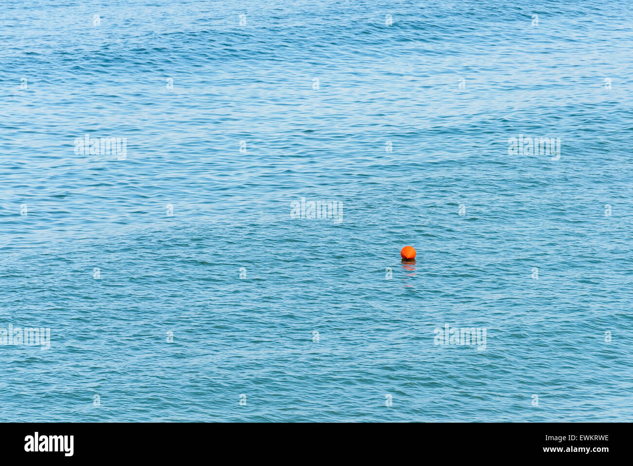 Orange Life Buoy Floating In The Middle Of The Ocean Stock Photo - Alamy
