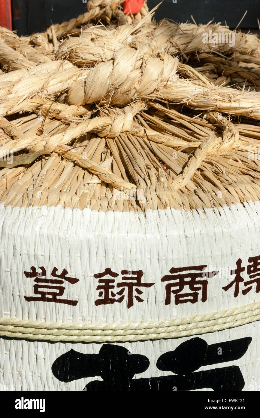 Japanese twisted knotted straw rope on top of massive sake barrel left ...