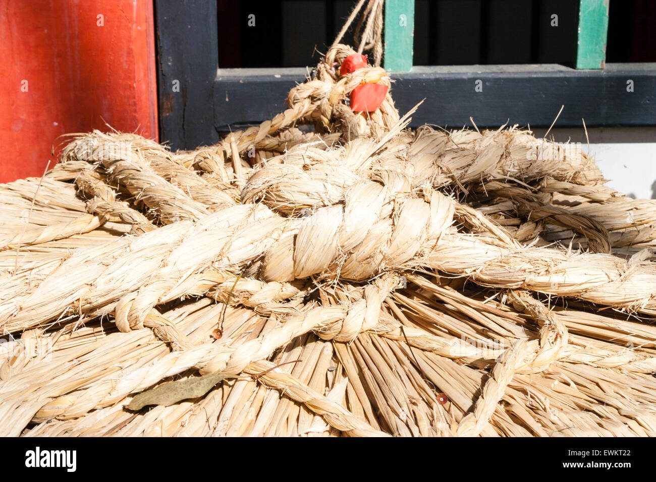 Japanese twisted knotted straw rope on top of massive sake barrel left ...