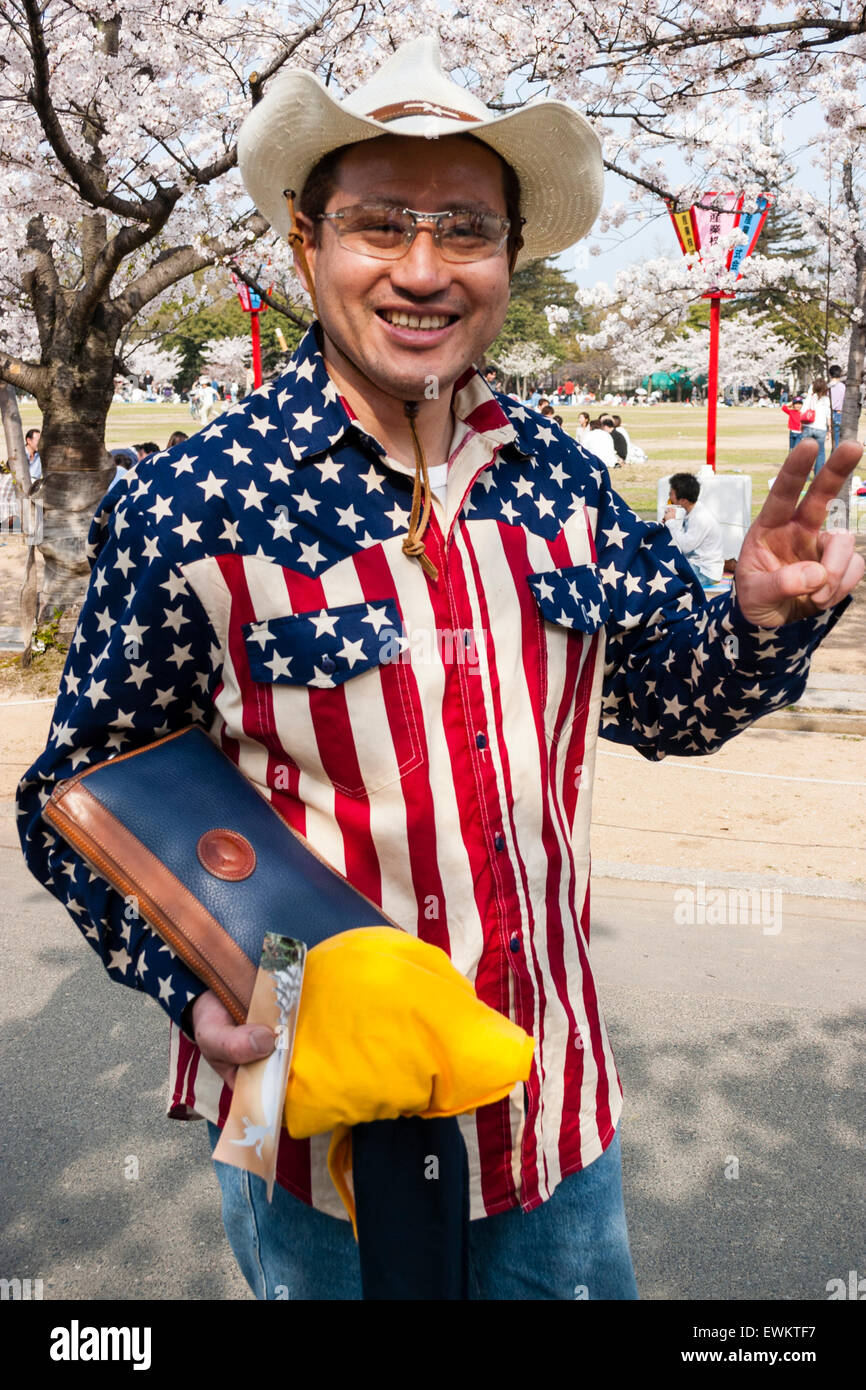 Smiling Japanese man posing under cherry blossoms in Japan. Wears stars ...