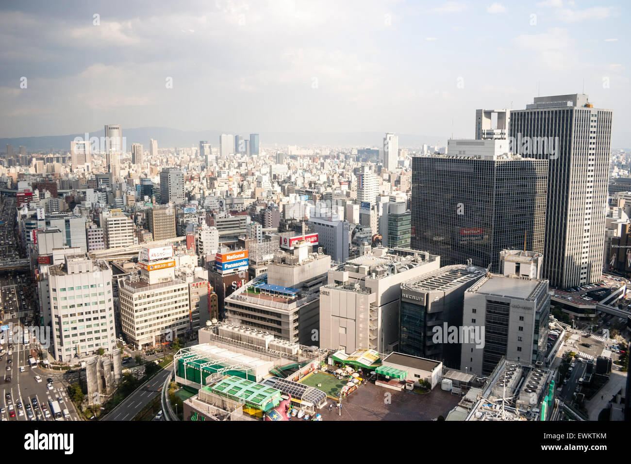 High rise roof top view of the city of Osaka. Mountains in the distant ...